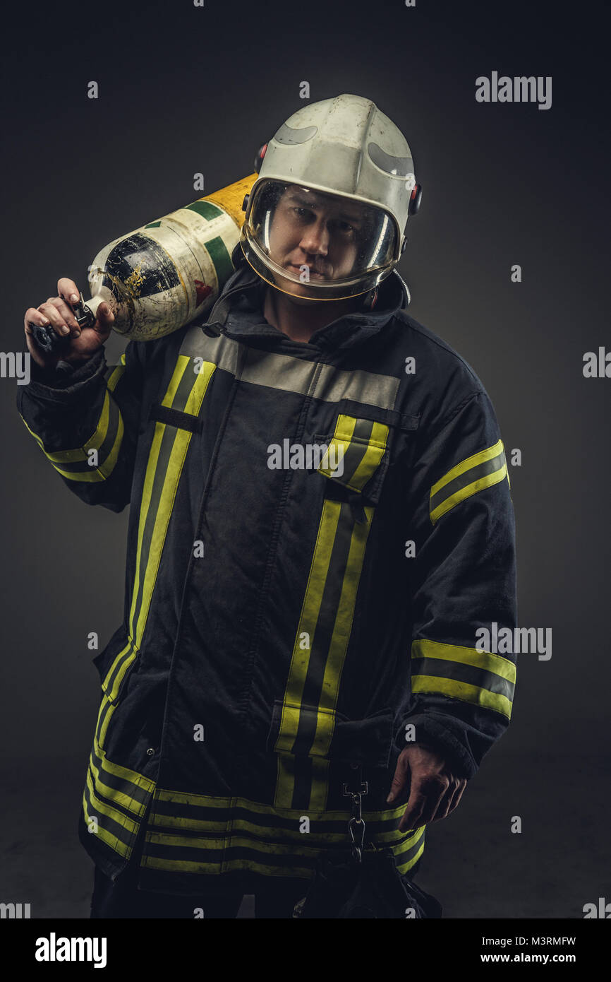 Firefighter in safety costume holding oxygen tank Stock Photo - Alamy