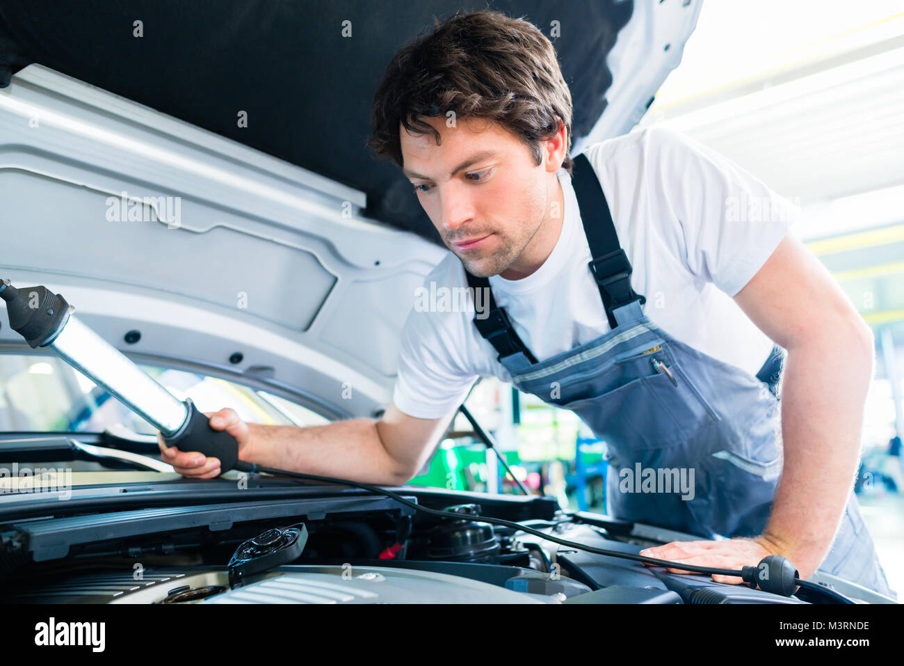 Auto mechanic working on car in service workshop Stock Photo - Alamy