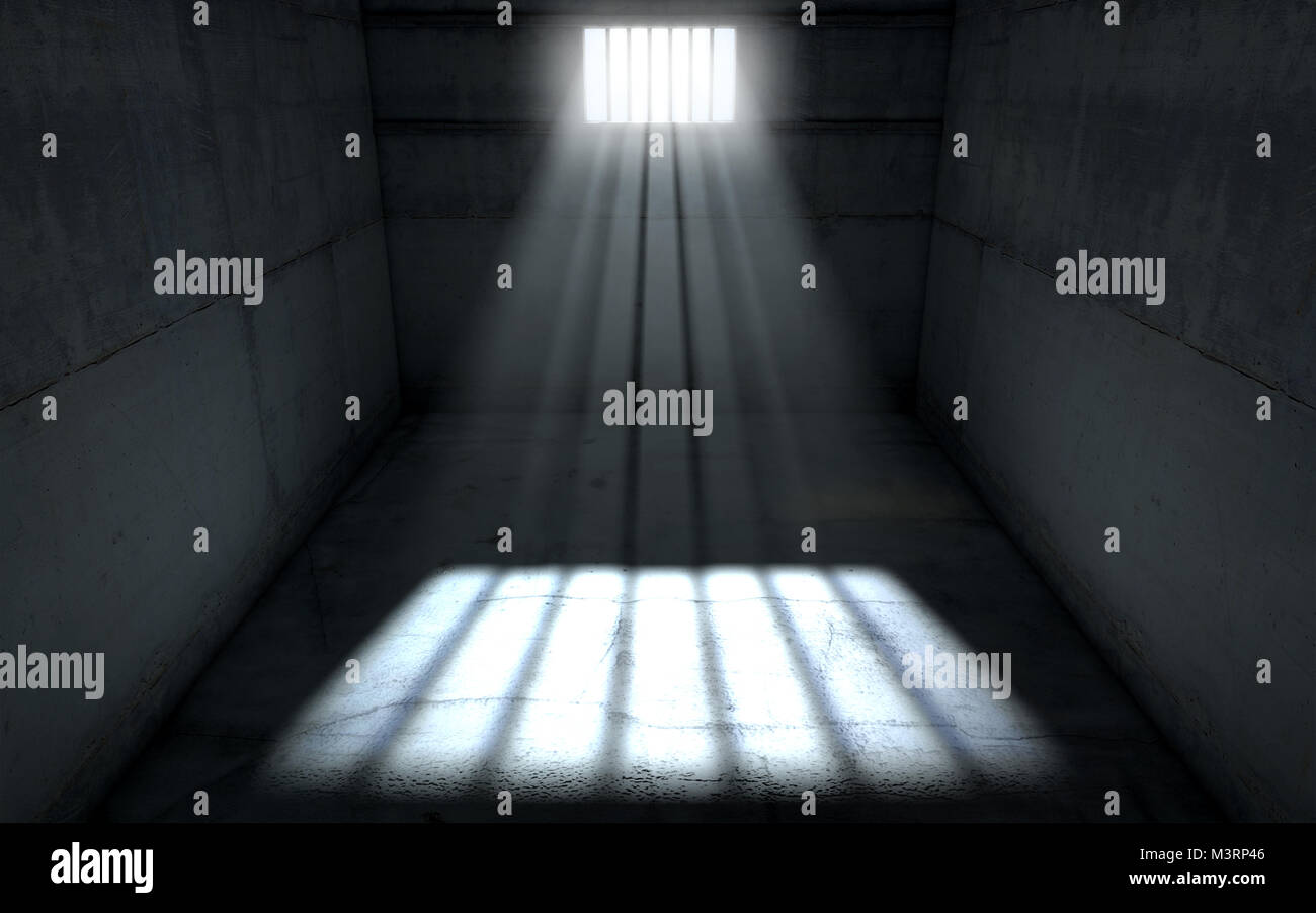 A jail cell interior with a barred up window and light rays penetrating through it casting its ...