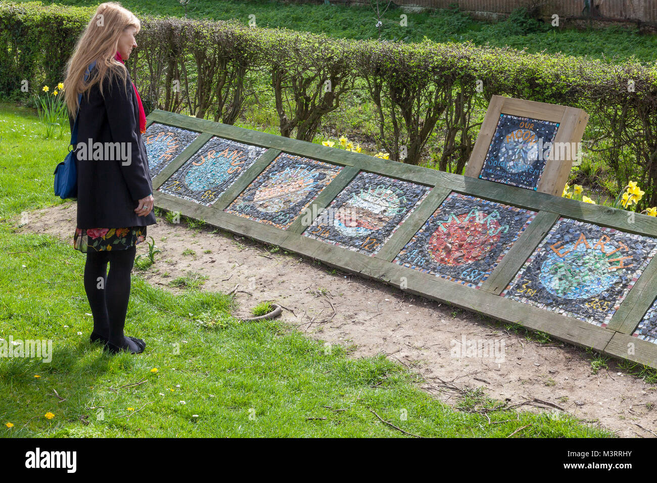 A woman views the Mosaic art work of the Solar System designed by ...