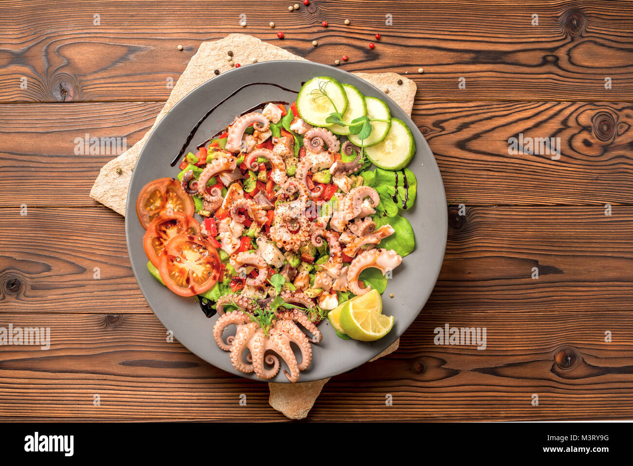 top down of salad with tentacles of octopus, lime, avocado and lettuce ...