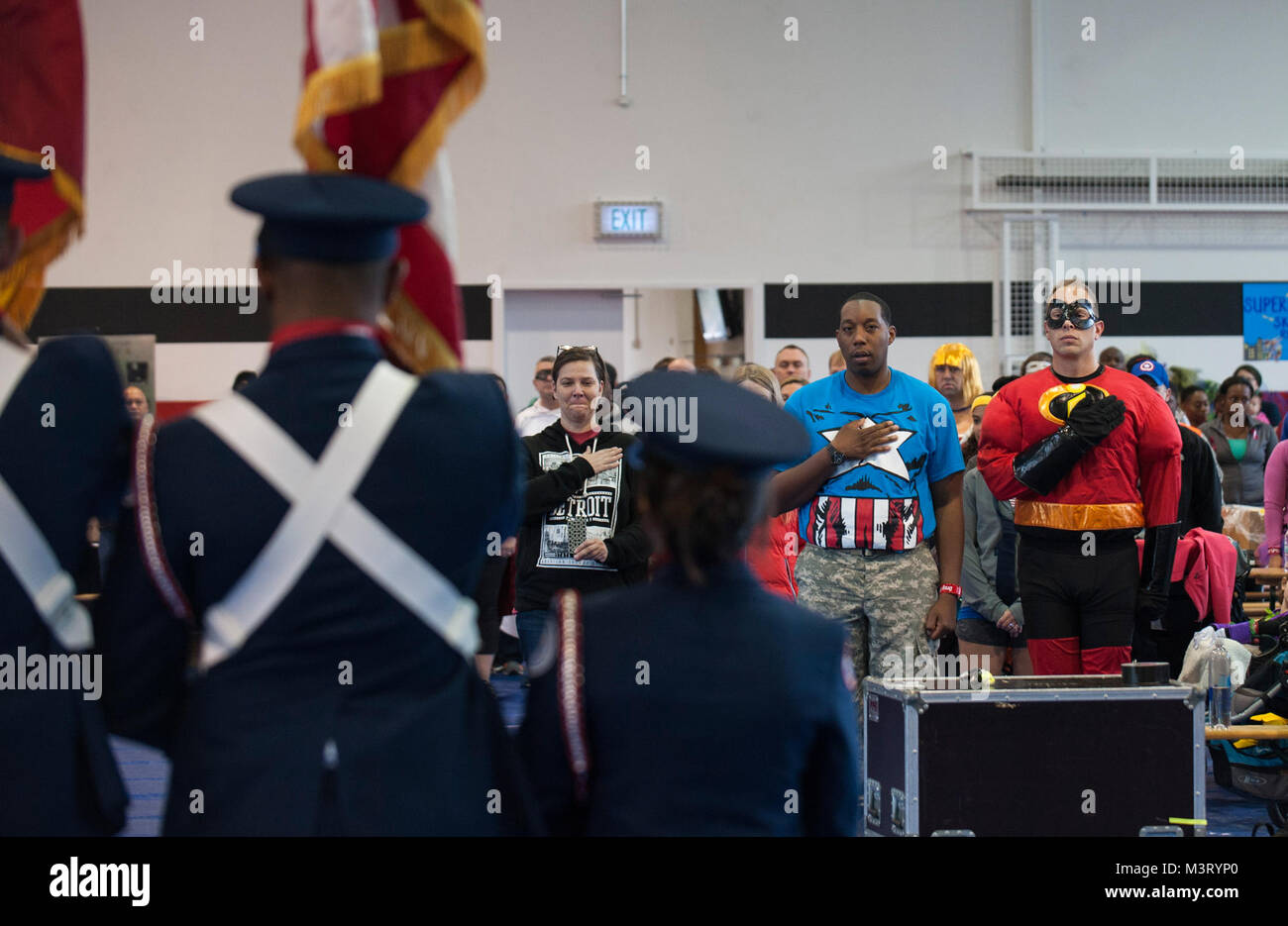 Participants of a Red Ribbon Run Superhero 5k event stand during the ...