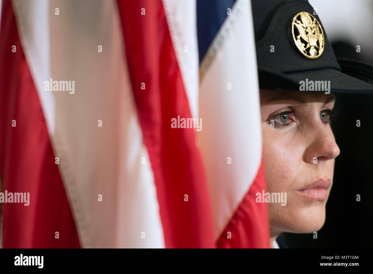 A soldier carries the American Flag during the change of command ...