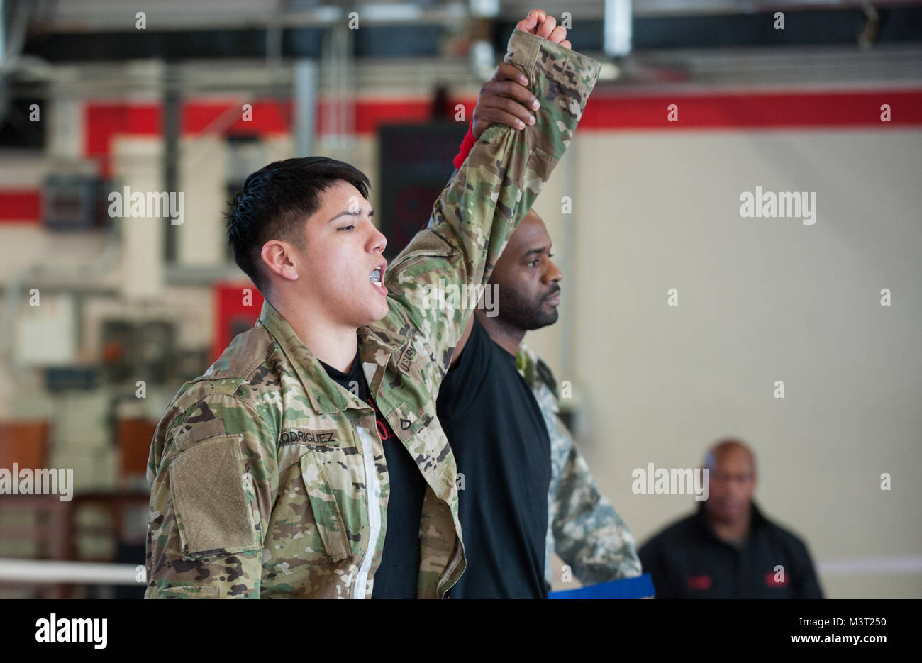 U.S. Army Private 1st Class Victor Rodriguez (left) raises his hand in ...