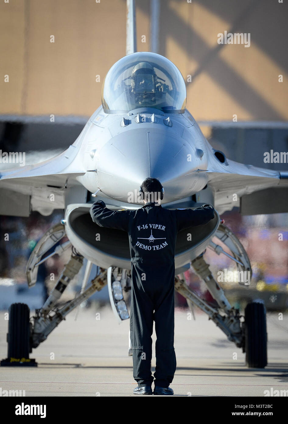 An F-16 Fighting Falcon is marshaled into position at Davis-Monthan Air ...