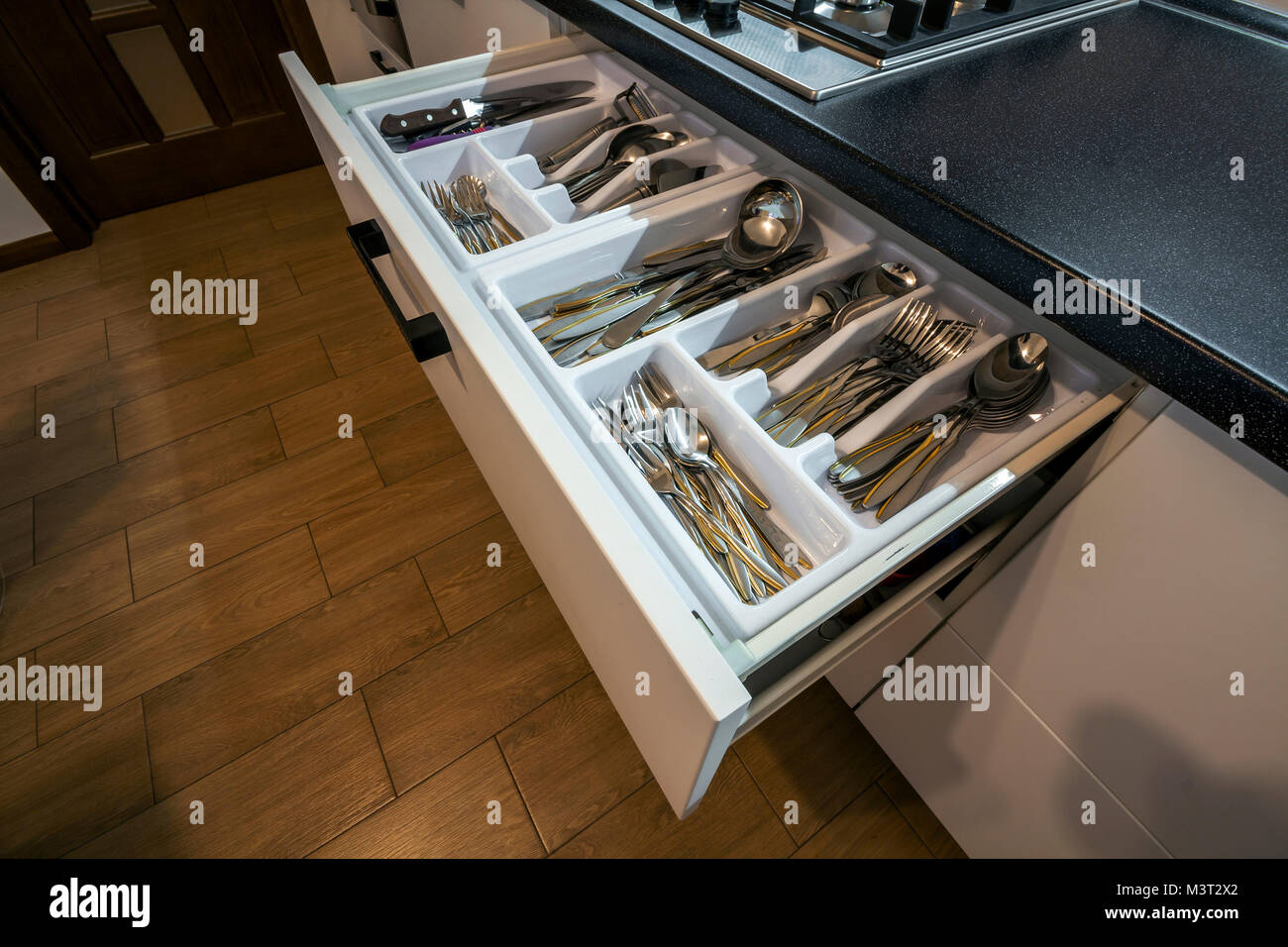 Stainless steel spoons, forks and knifes in cutlery box drawer in white ...