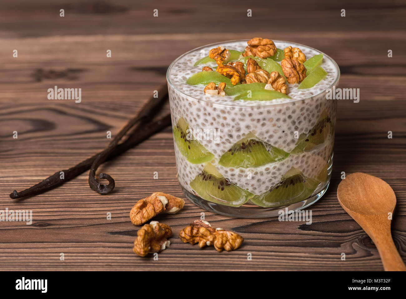 chia seed pudding in glass cup made with kiwi, decorated walnuts ...