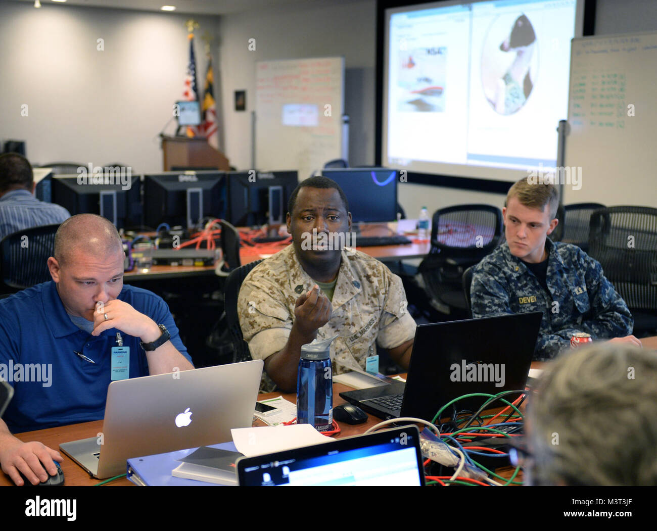 Marine Gunnery Sgt. Dadrian Mills (center) conducts Cyber Defense ...