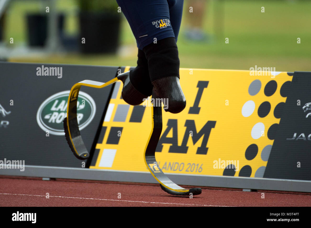 A runner with a pair of running blades runs past the 2016 Invictus ...