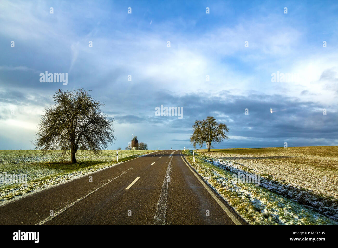 Empty black asphalt road between green fields Stock Photo - Alamy