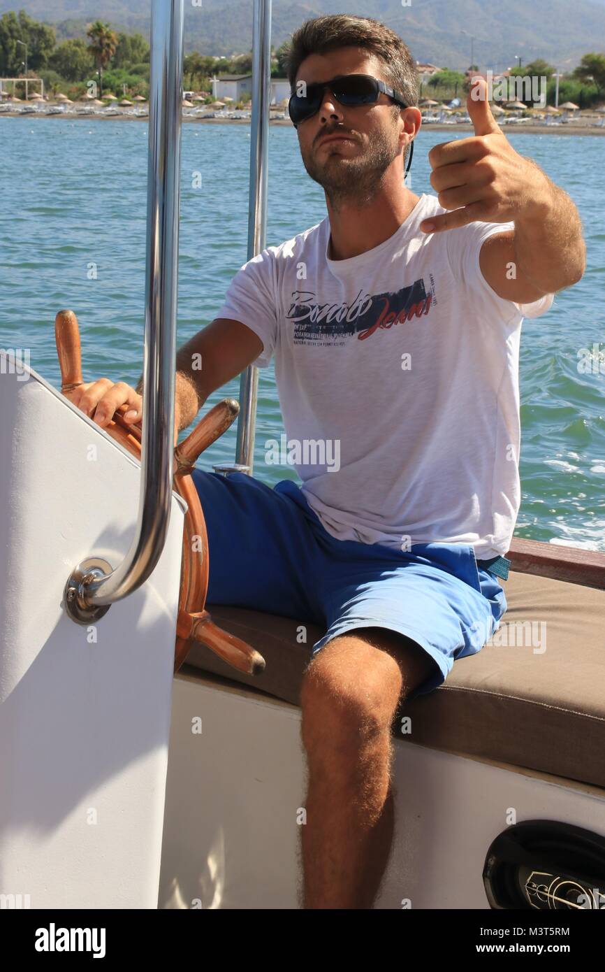 Young man steering boat hi-res stock photography and images - Alamy