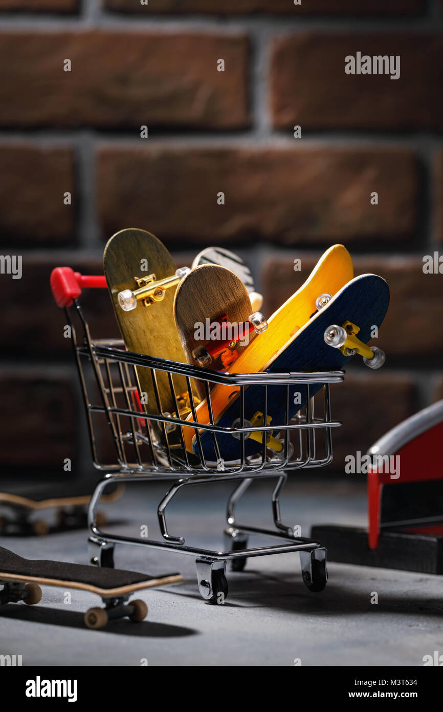 Fingerboards in a basket on a brick wall background with space for text ...