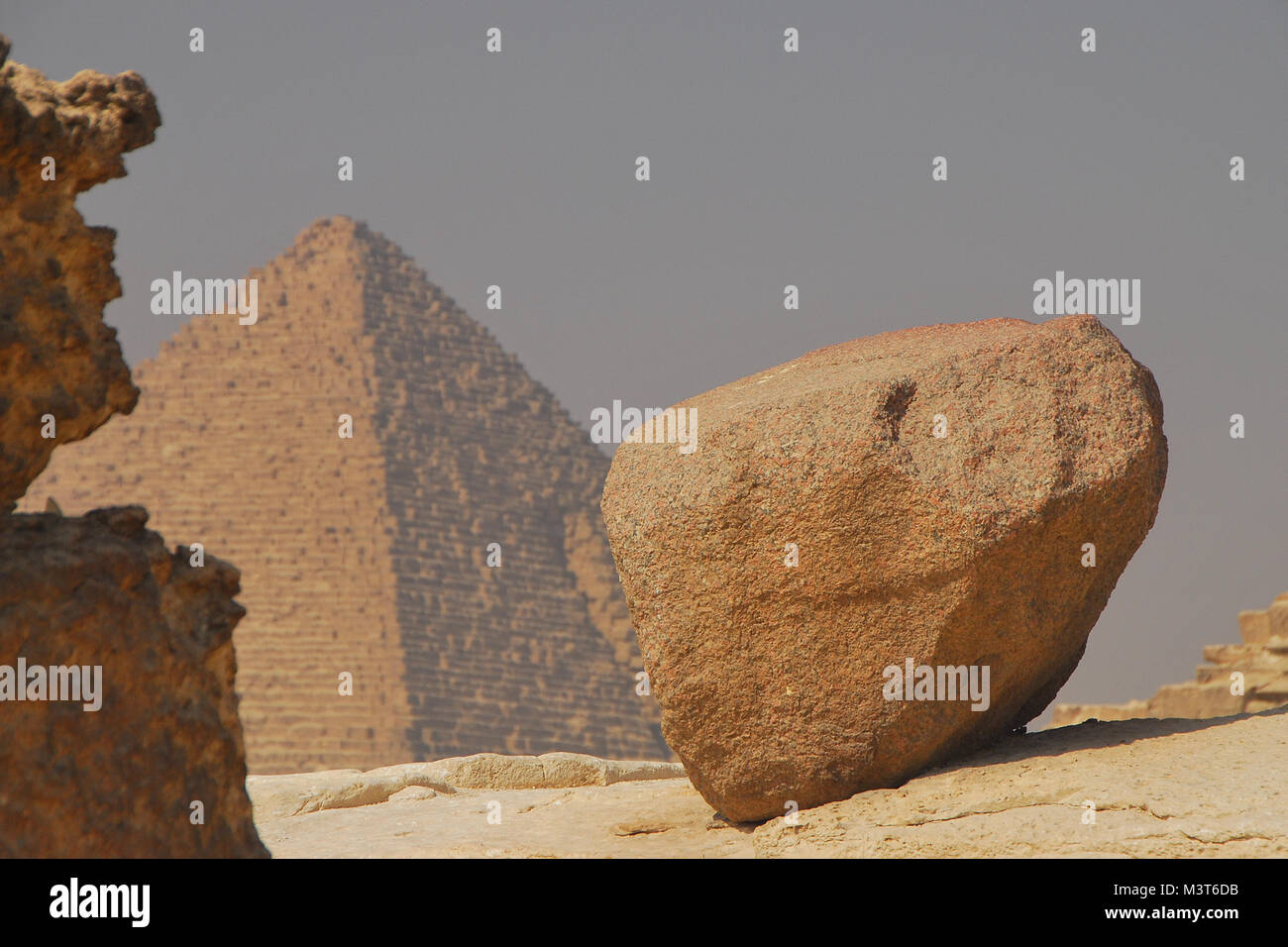 large stone with a pyramid in the background Giza, Cairo Egypt Stock ...