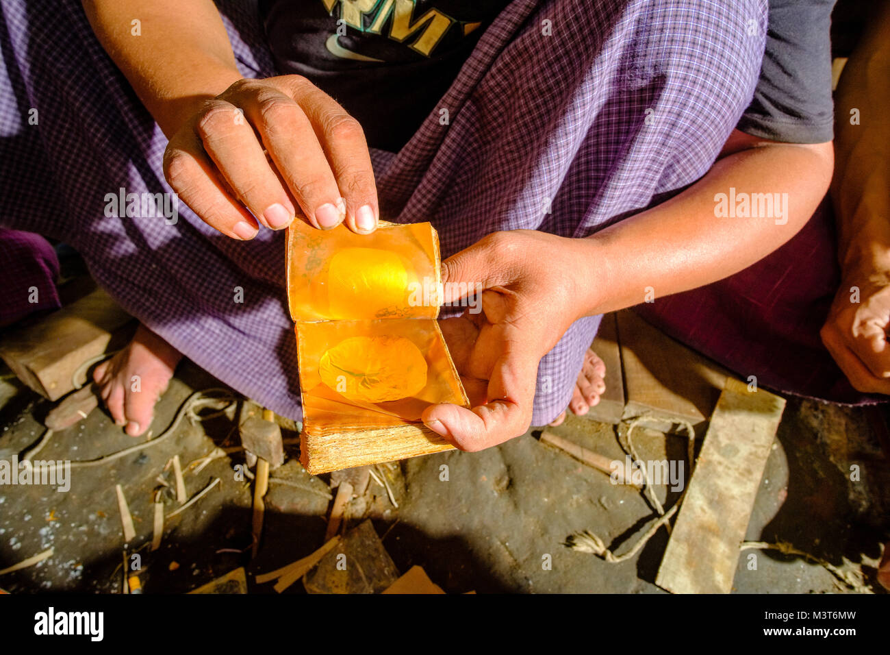 Close up of a worker checking very thin layers of beaten gold Stock ...