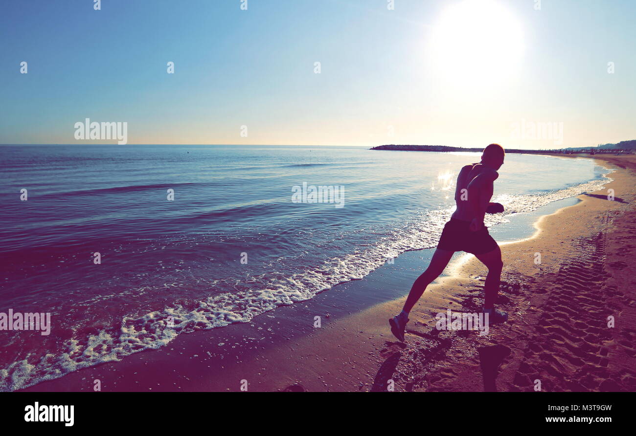 Man runs fast on the beach at dawn Stock Photo - Alamy