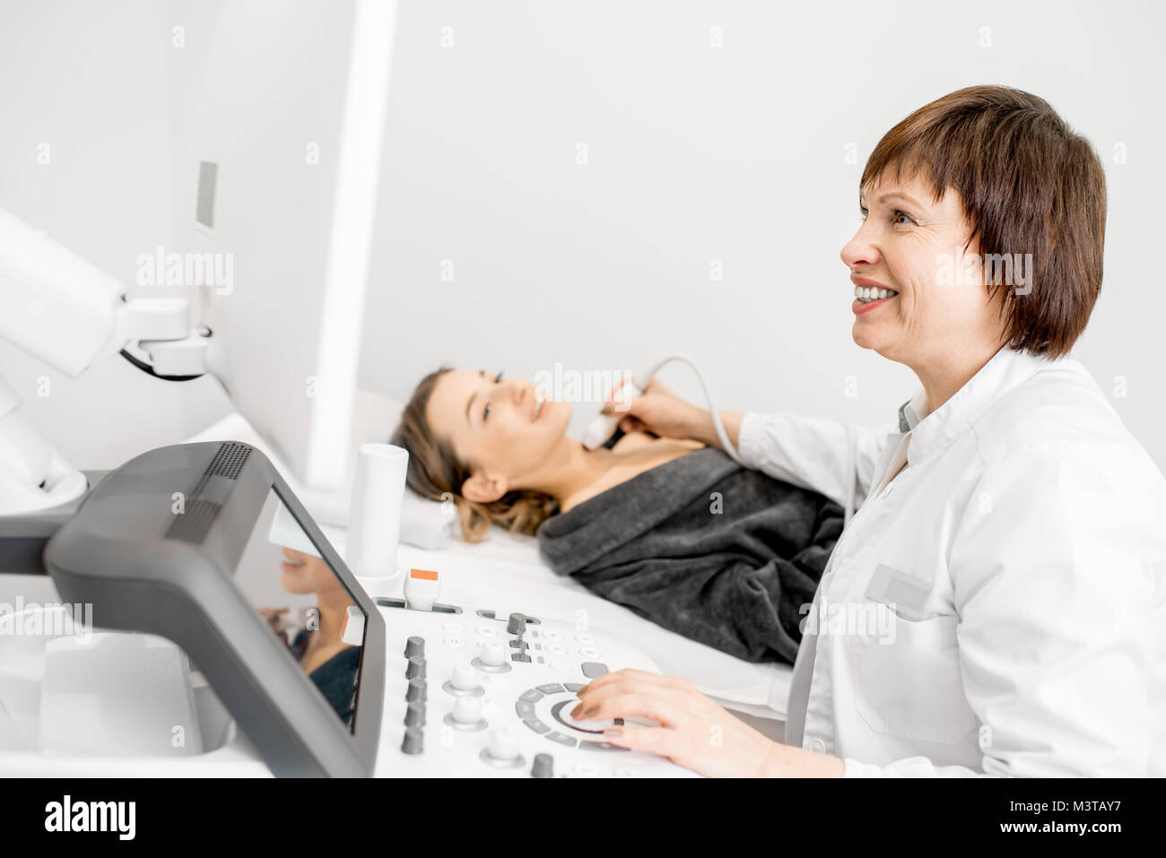 Doctor making ultrasound examination to a young woman Stock Photo - Alamy