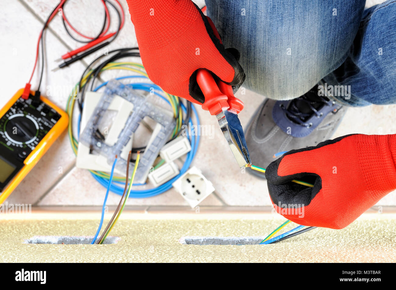 Electrician technician at work with pliers on the cable of in a ...