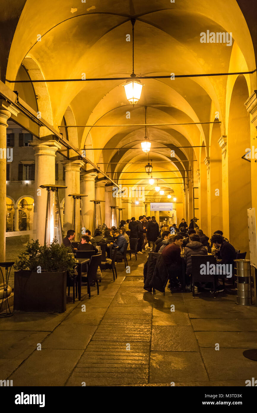 Cafes line a portico facing Piazza Grande at night in Modena Italy ...