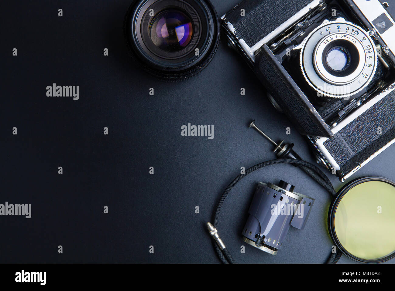 Vintage photo camera film with lens and photographic equipment on black ...