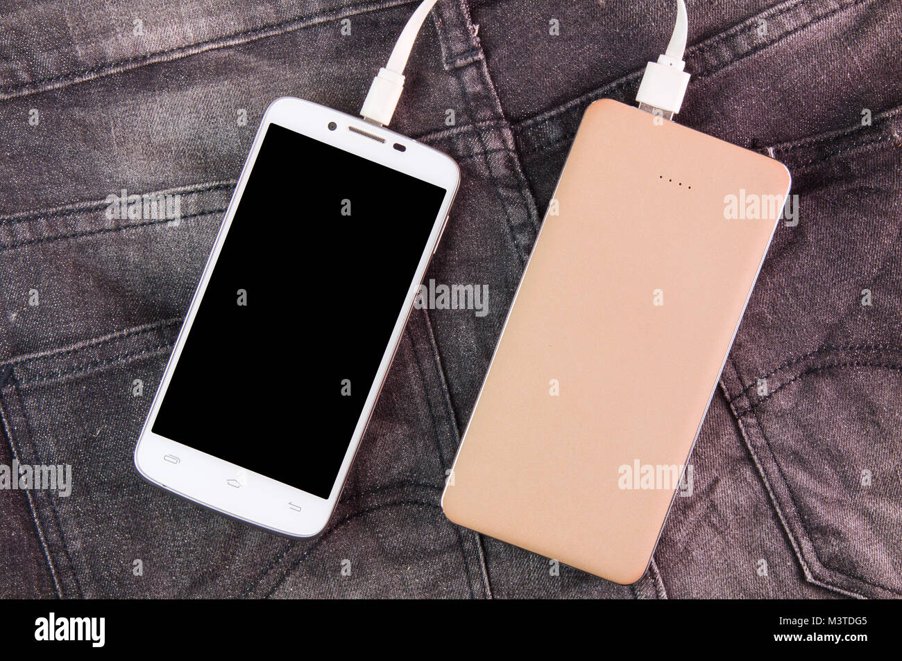 Mobile phone portable battery recharging a smartphone on jeans ...
