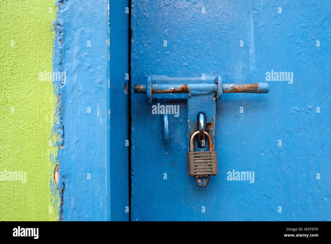 Old lock on the door but the door is opened. Green and blue wall Stock ...