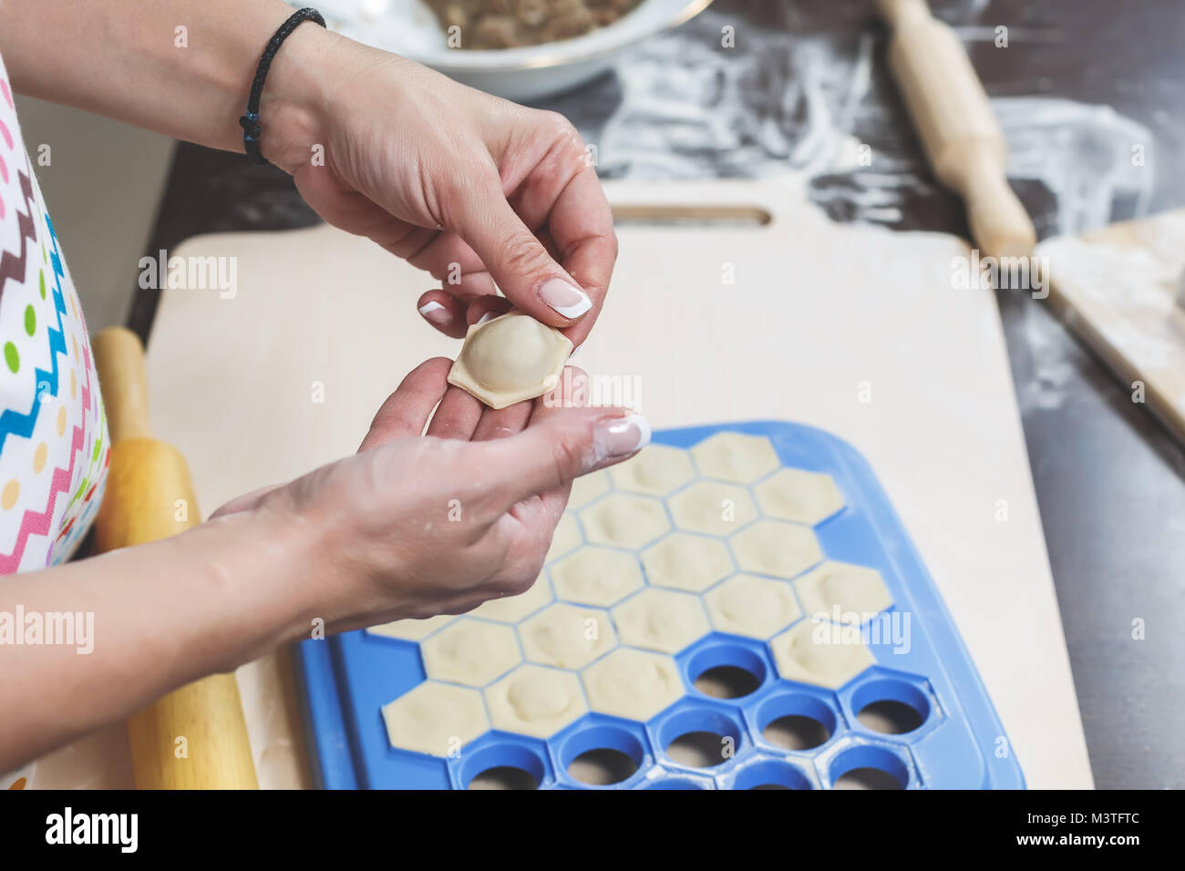 The process of making delicious homemade dumplings. Female hands hold ...