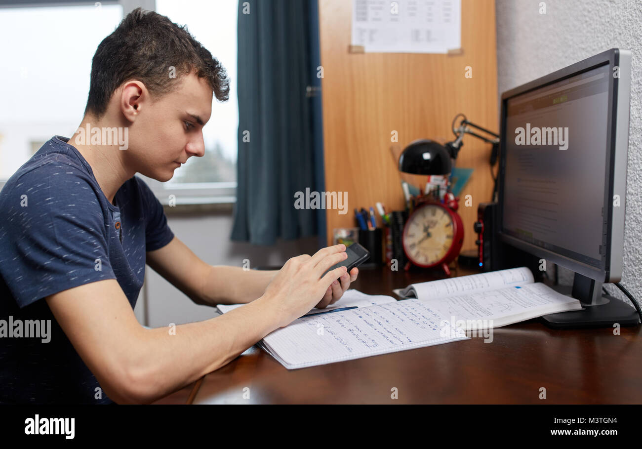 Student doing homework at his desk with computer Stock Photo - Alamy