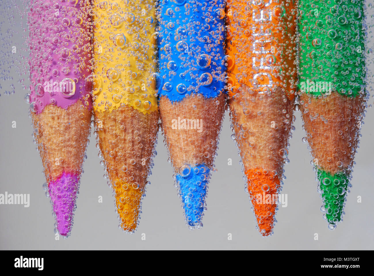 five colored pencil with many bubbles are in the water Stock Photo - Alamy