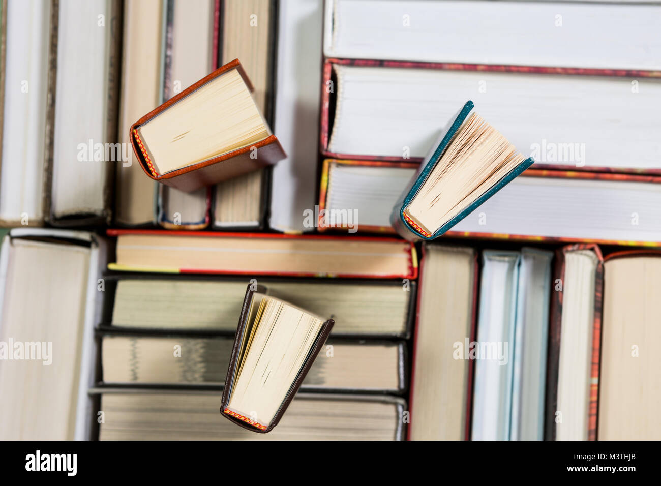 Pile of various books on bright wooden background. With copy space for ...