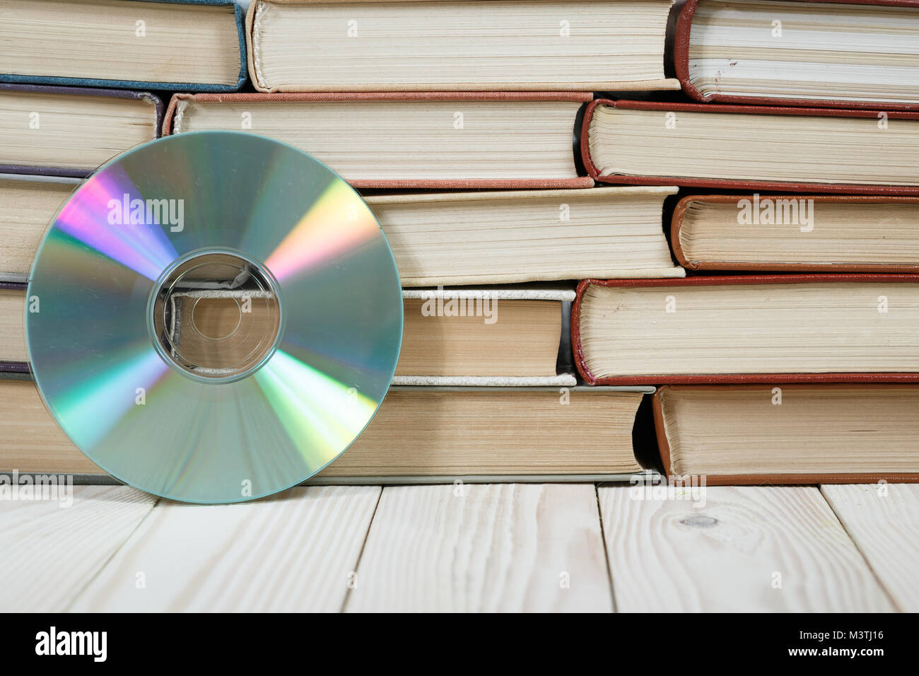 Pile of old books stacked on top of each other with a compact disc, the ...