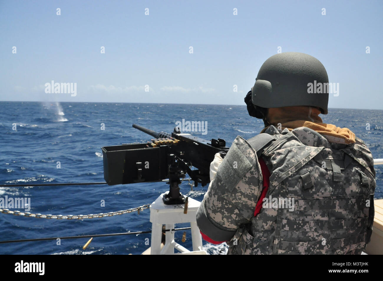 A crew member from the Coast Guard Cutter Heriberto Hernandez shoots ...
