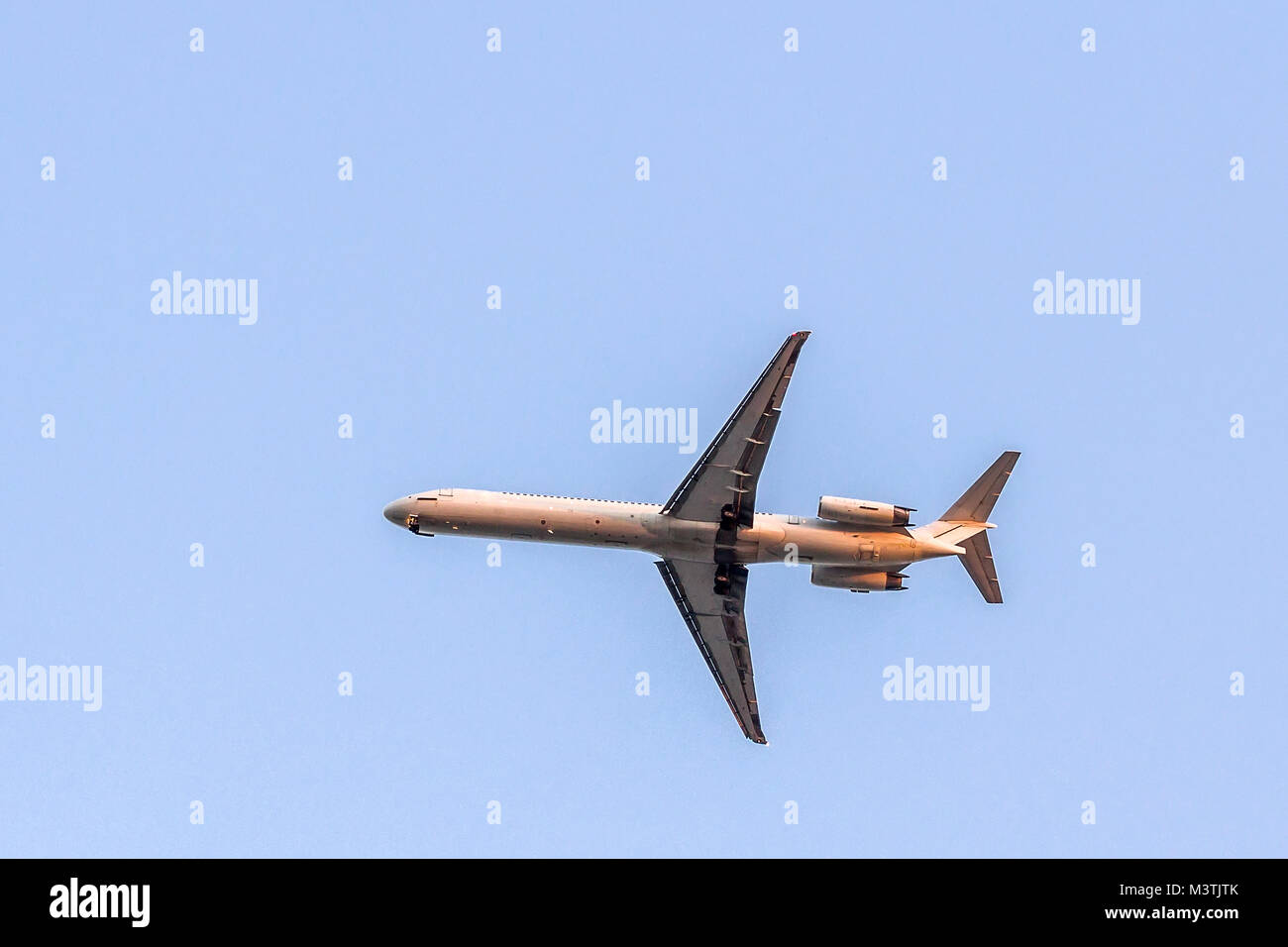 Flying commercial two engine airplane against clear blue sky. Passenger ...