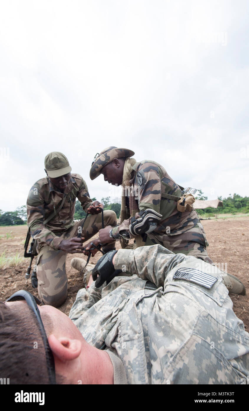 Two Gabonese Armed Forces Soldiers create an improvised tourniquet for ...