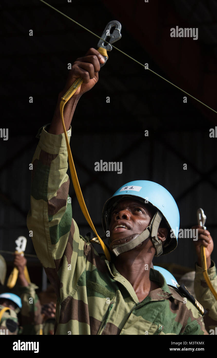 A Gabonese Armed Force’s paratrooper clips into parachute line while ...