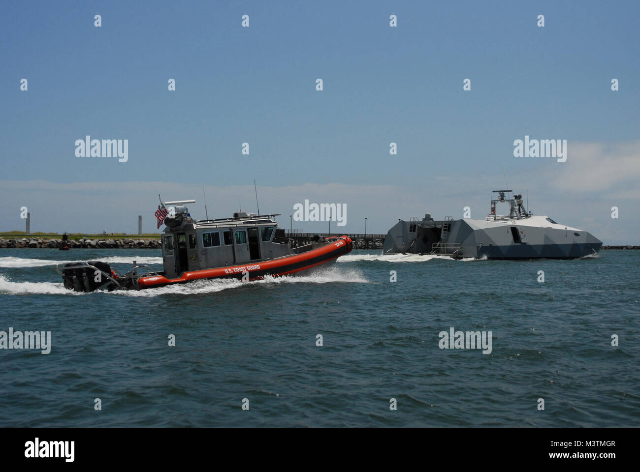 A U.S. Coast Guard defender-class boat accompanies the experimental ...
