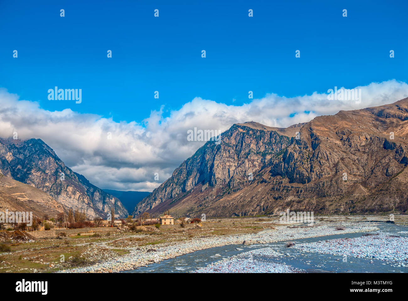 rural province scene of village between mountains and small river Stock ...