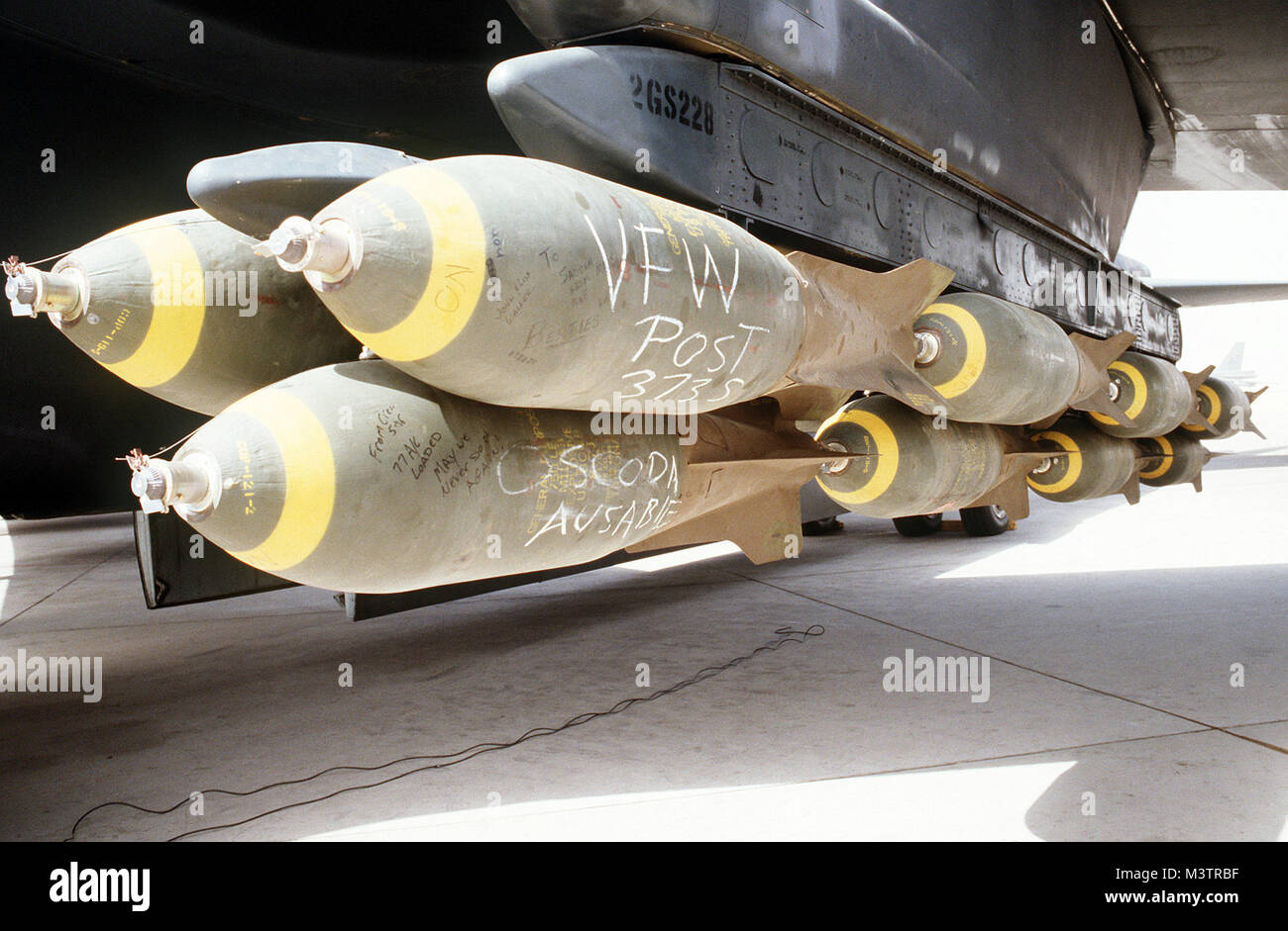 A close-up view of M-117 750-pound bombs loaded onto the pylon of a B ...