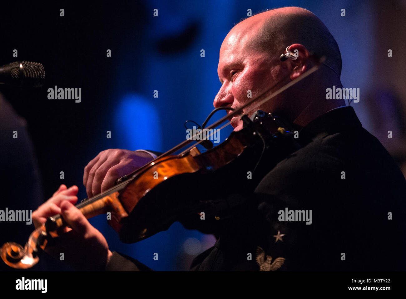 Senior Chief Musician Patrick J. White plays the fiddle during a ...