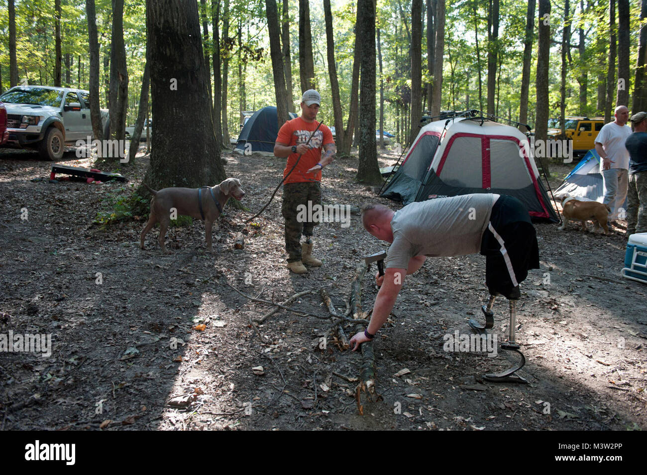 Curtin (right) chops wood while Marine Corps Lance Cpl. John Patterson ...