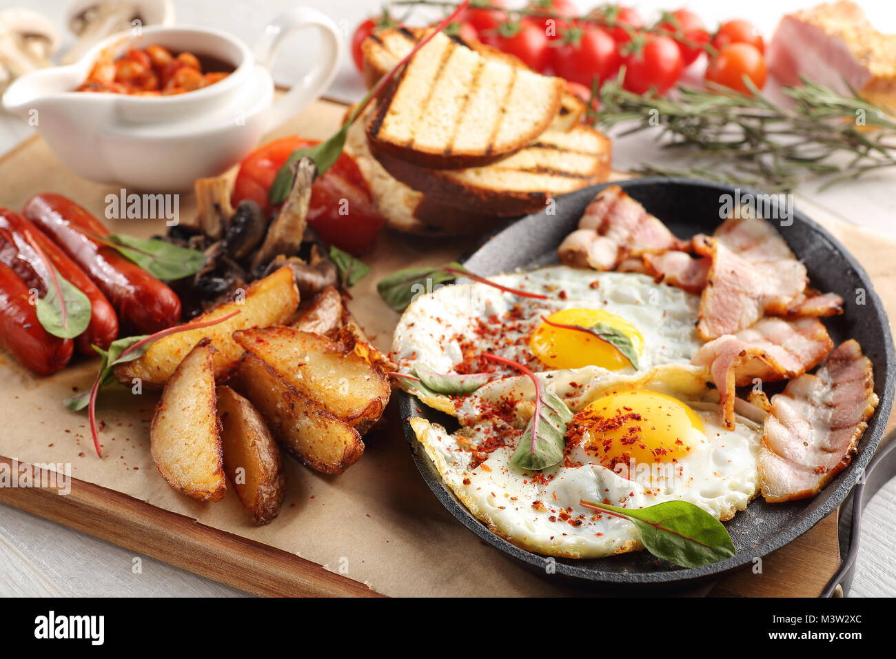 close up of rustic full english breakfast on a white wooden table Stock ...