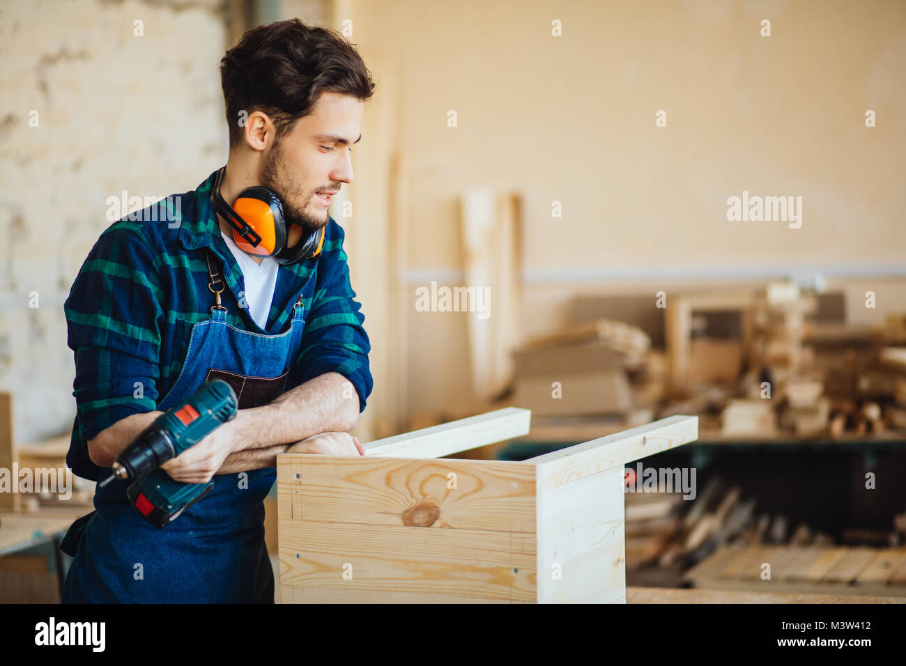 Young male carpenter in workshop looking at camera Stock Photo - Alamy
