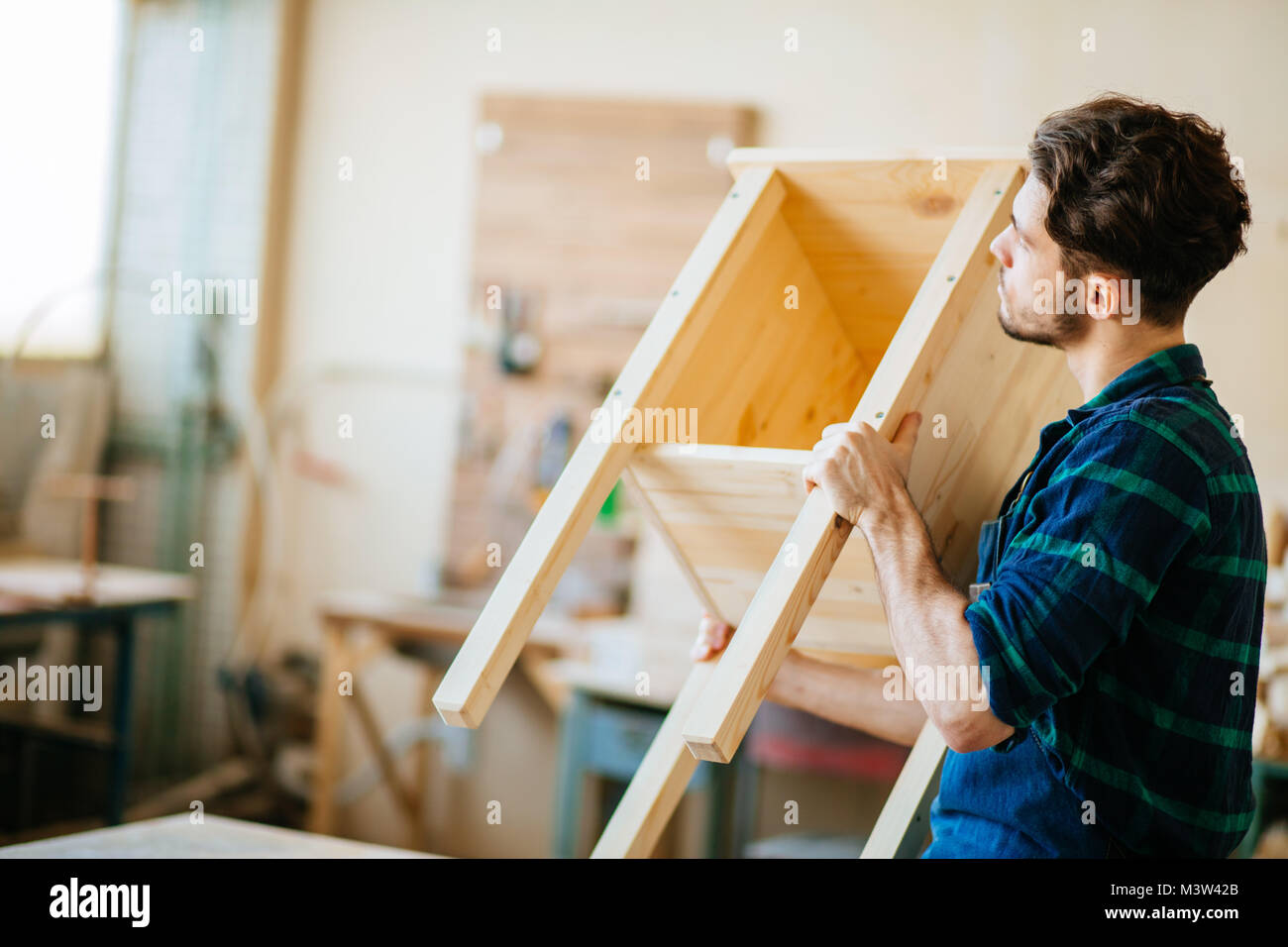 carpenter testing wood plank evenness at workshop Stock Photo - Alamy
