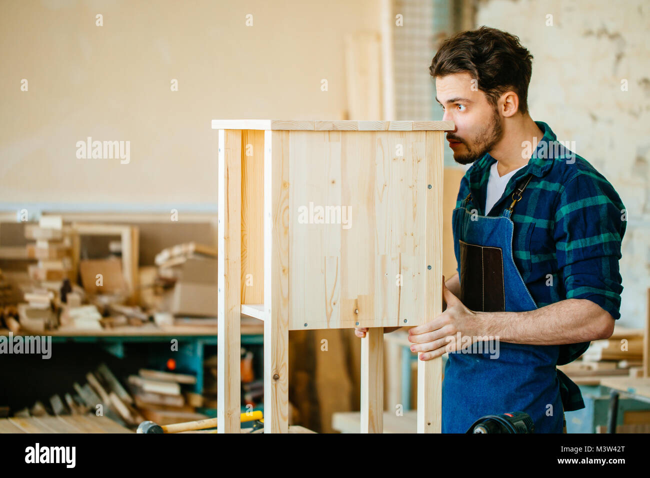 carpenter testing wood plank evenness at workshop Stock Photo - Alamy