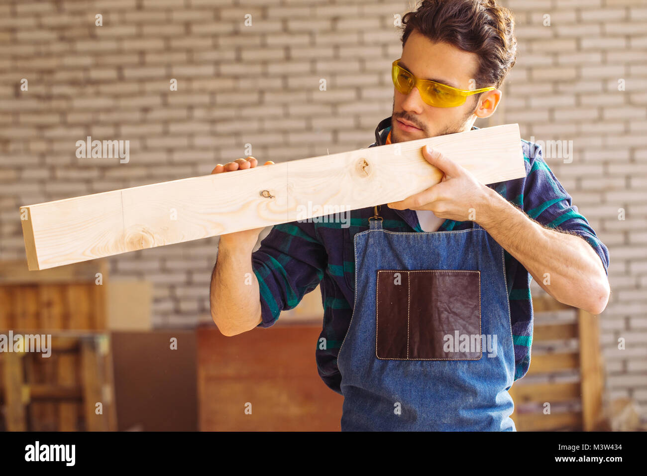 carpenter testing wood plank evenness at workshop Stock Photo - Alamy