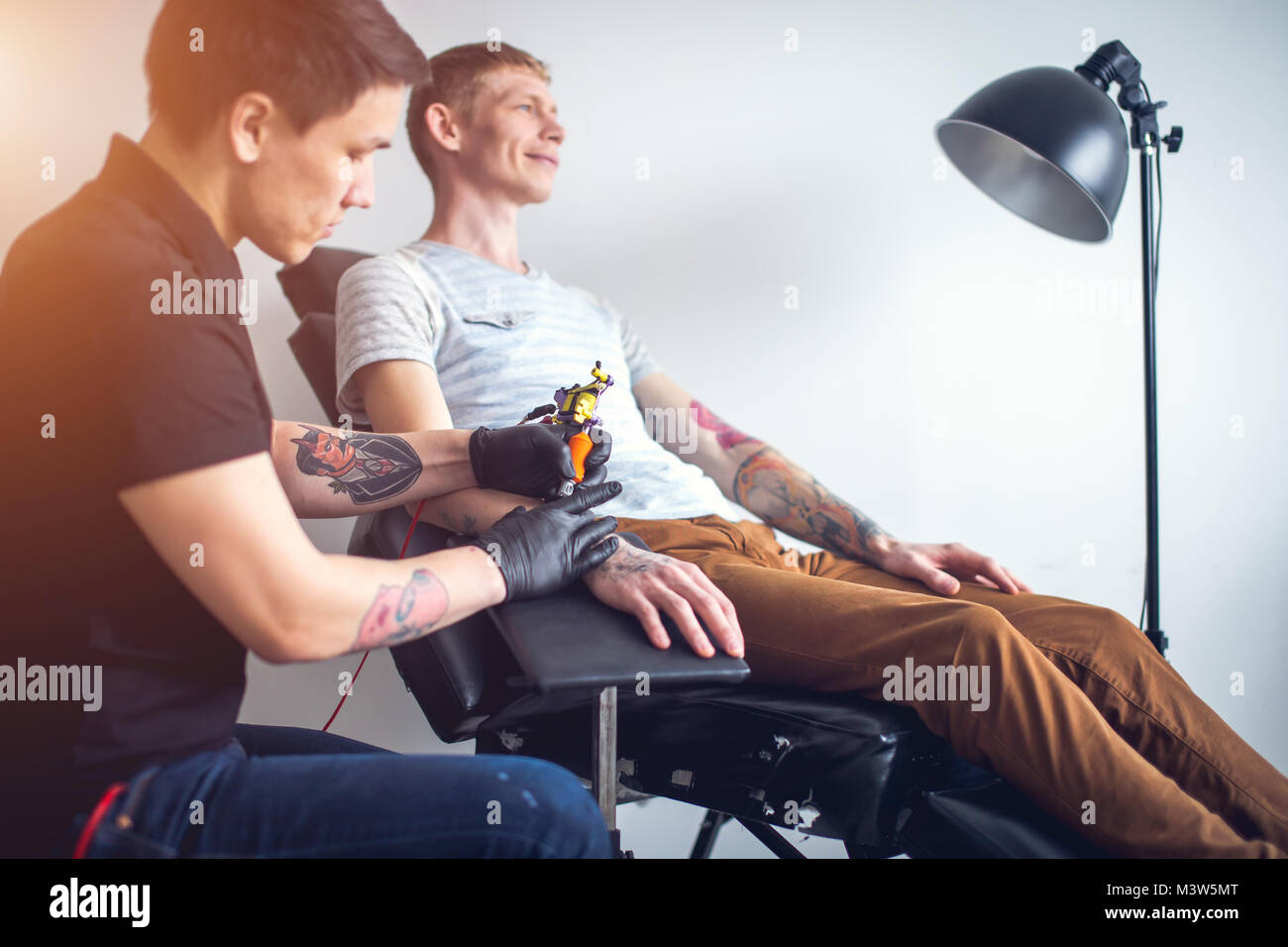 Master tattoo artist in gloves makes tattoo Stock Photo - Alamy