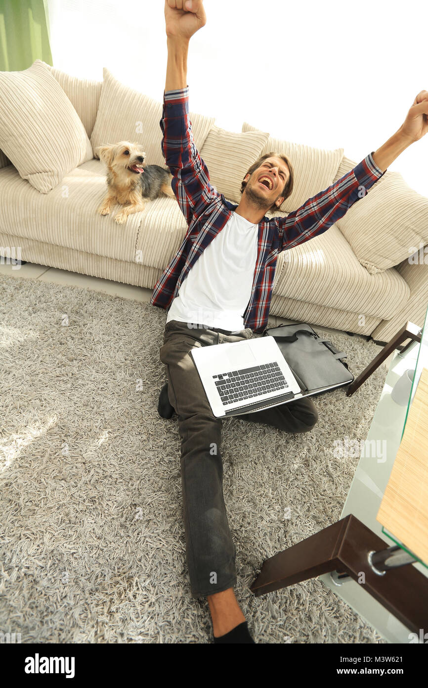 happy guy with laptop jubilant in spacious living room Stock Photo - Alamy