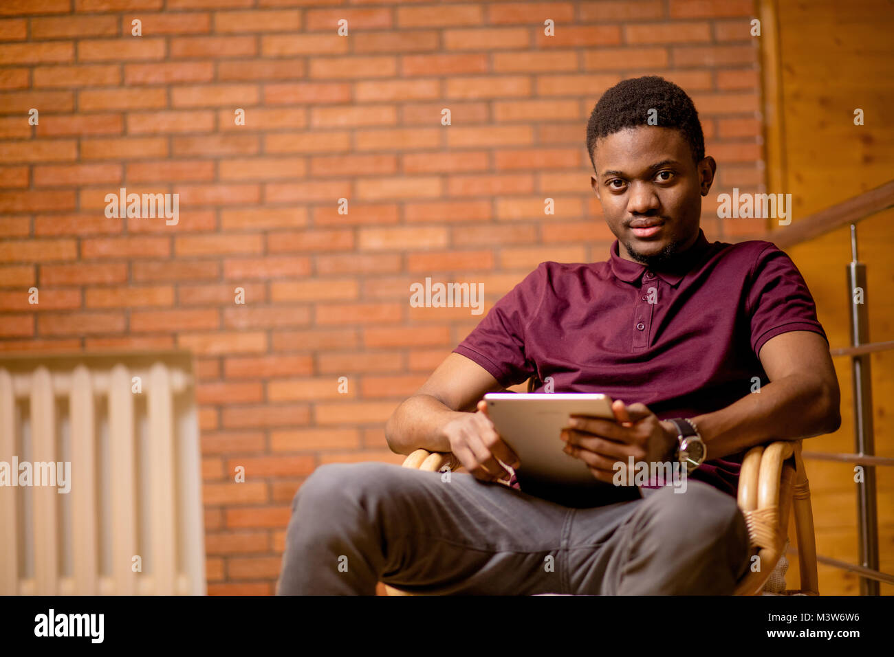 African man using tablet for video conversation while relaxing on ...