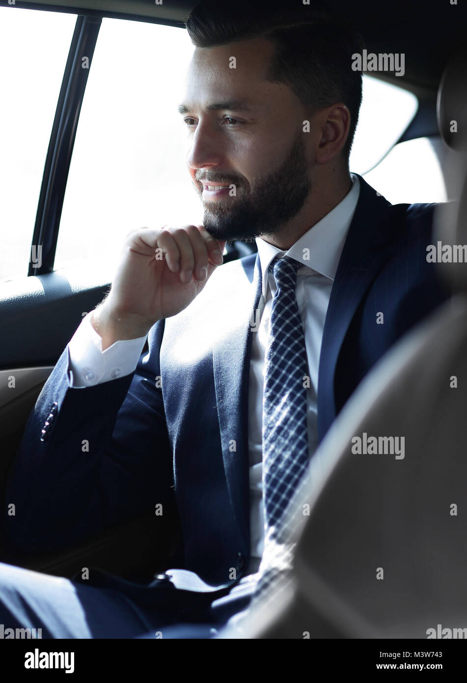 Smiling business man sitting in the back seat of a car Stock Photo - Alamy