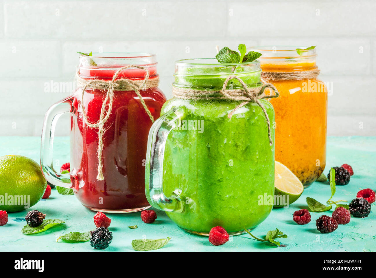 Healthy fresh fruit and veggie smoothies with ingredients on light blue ...