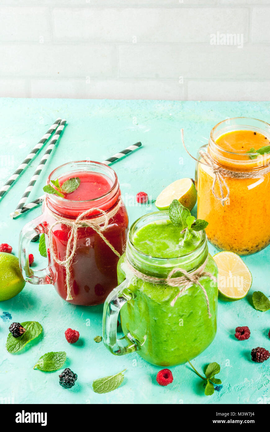 Healthy fresh fruit and veggie smoothies with ingredients on light blue ...